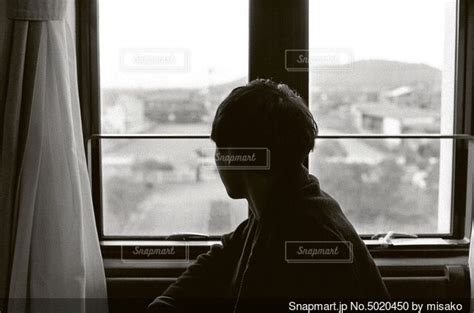 窓の前に座っている男の写真・画像素材[5020450] Snapmart（スナップマート）