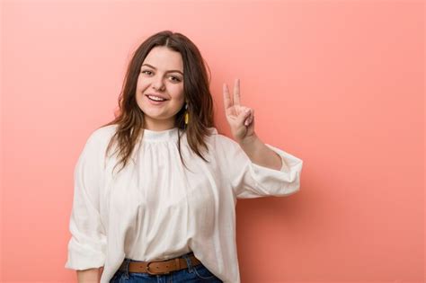 Premium Photo Young Caucasian Curvy Woman Standing Against Pink Wall