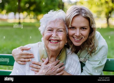 Portrait Of Adult Granddaughter Hugging Her Senior Grandmother When