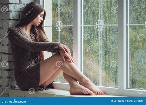 Beautiful Young Woman Sitting Alone Near Window With Rain Drops And