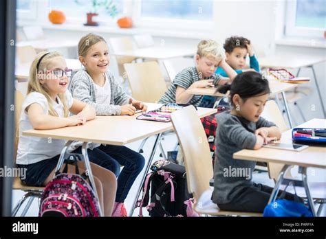 Los Alumnos Sentados En Pupitres En Clase Fotografía De Stock Alamy