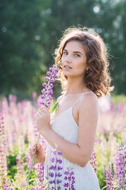 Premium Photo Girl With A Bouquet Of Lupine On The Field