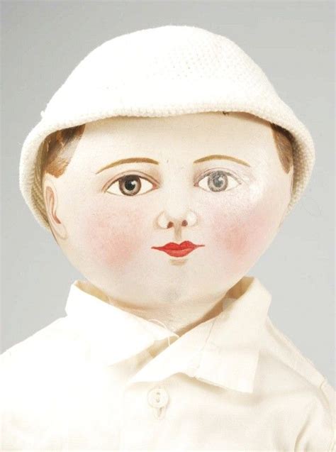 An Old Doll Wearing A White Hat And Dress Shirt With Red Lipstick On It