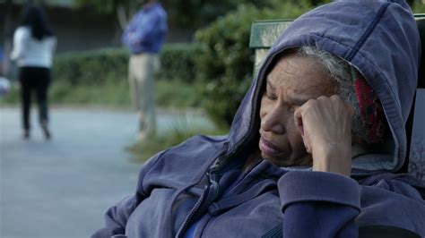 homeless woman looks into camera with annoyed look and