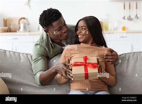 Loving African American Man Hugging His Wife Giving Present Stock