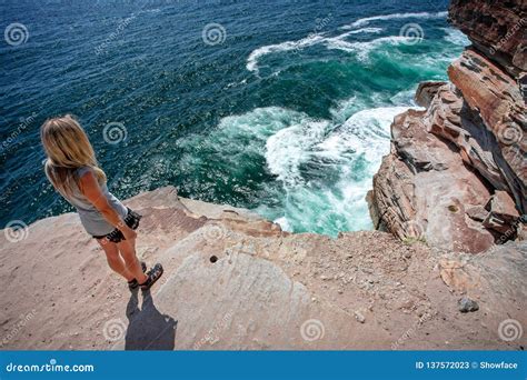 Female Takes In The Ocean Views From Cliff Top Ledge Royalty Free Stock