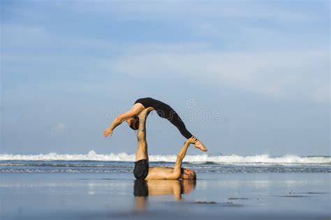 Young Attractive And Beautiful Acrobat Couple Practicing Acroyoga