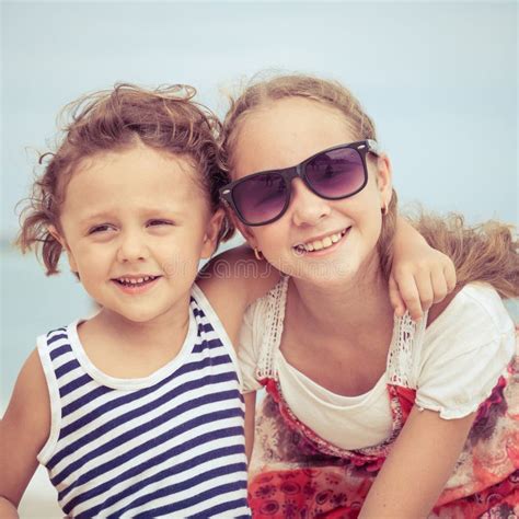 Hermana Y Hermano Que Juegan En La Playa En El Tiempo Del Día Imagen De