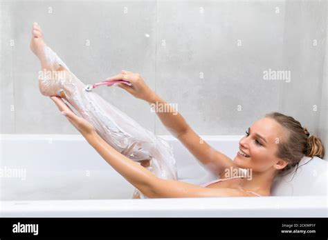 Image Of Young Beautiful Woman In Bathroom Lies Resting In Bath Shaving