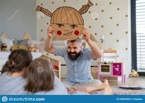 Father With Three Daughters Indoors At Home Playing On Floor Stock