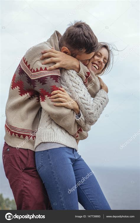 Happy Thoughtful Couple Standing On A Cliff Near Sea Hugging Eac Stock