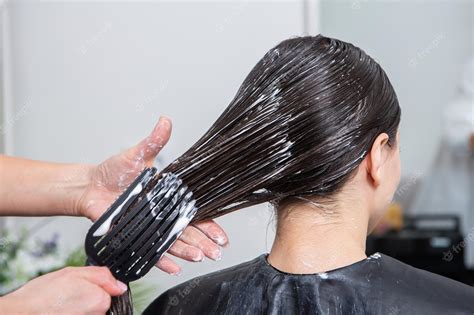 Premium Photo Hairdresser Applies A Hair Mask To Straight Black Hair