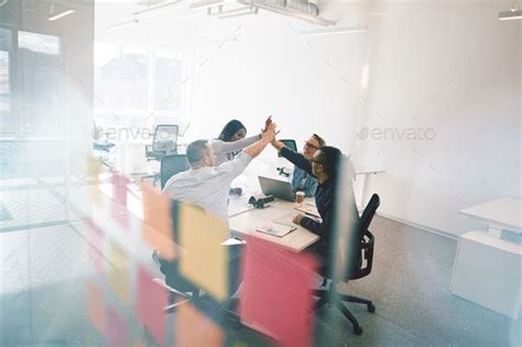 Diverse Coworkers High Fiving Together During An Office Meeting