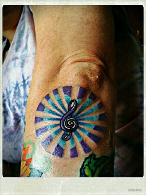 a woman's arm with a colorful tattoo design on her left arm and the ...