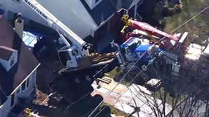 Landscaping crane tips over and gets caught on power lines