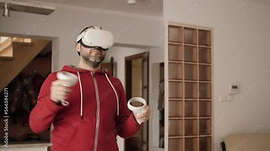 Man At Home Wearing Virtual Reality Headset Holding Gaming Controllers. VR Tester in White Headset Moves Hands With Controllers Man Playing Games On Virtual Reality Device. Technology