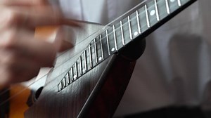 Hands strumming quickly on classic balalaika, playing quickly. Acoustic string musical instrument