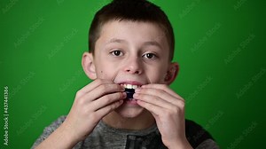 The boy on a green background puts on a plate for alignment of front upper teeth, alignment of upper teeth.