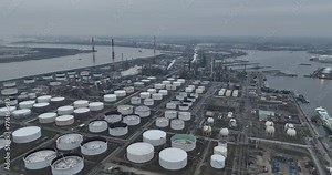 Large petrochemical cracking refinery in the port of Antwerp. Producing fossil fuels. Aerial dorne view at dusk. Large storage containers and industrial installation.