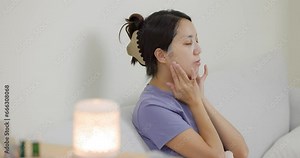 Woman apply face mask on face and sit at home