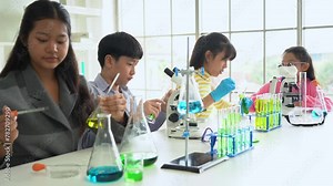 group of excited asian school kid doing chemical experiment in laboratory together. pupil students science testing chemistry class in the lab together
