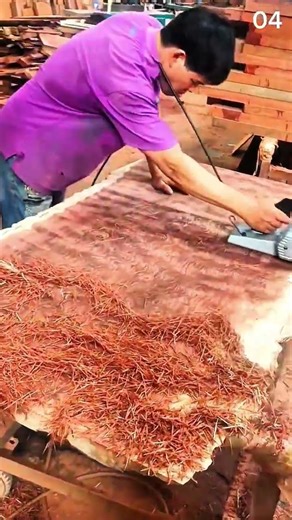 Workers smooth the wood surface using a sanding machine.