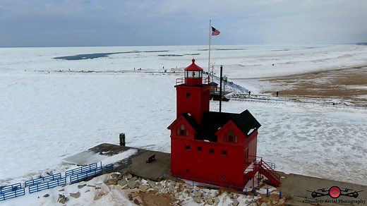 Stunning ice buildup around Holland's Big Red Lighthouse and of course people climbing all over it. | Timeless Aerial Photography