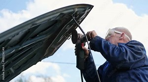 Car body shop. Repair man processes the welding seam using an angle grinder on replaced car part. Professional Body master grind old paint and rust. Rusty damage. Rusting car. Hands with tool close-up