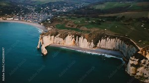 Drone approaching epic white chalk cliff bay coastline and amazing azure sea near beautiful town of Etretat Normandy.