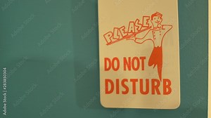 A vintage Please Do Not Disturb sign hanging on a bluish green door at a Route 66 motel