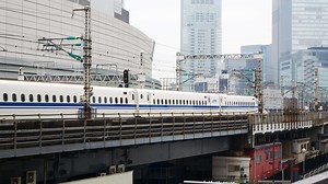 view to bullet high speed train on railway track while moving fast through the city of Tokyo in Japan