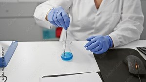Scientist woman conducting experiment with blue liquid in laboratory flask indoors.