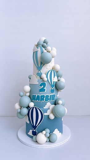 K CAKE on Instagram: "hot air balloon cake with a graceful transition from deep blue to light blue to white. I’ve crafted the hot air balloon using modeling chocolate and added my signature chocolate bubbles for that special touch."