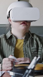 Vertical shot of female software tester with Down syndrome using VR headset with remote controller during workday in office