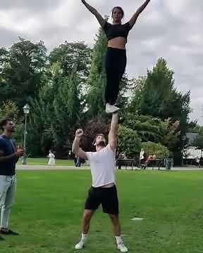 Girl Slips and Falls While Practicing Cheerleading Tricks With Guy in Park - 1096916