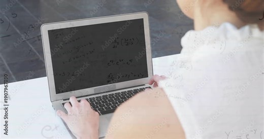 Student typing on laptop, pausing then reaching for tablet and comparing math formulas on screens