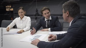 Team of corporate workers are explaining benefits og new marketing strategy and selling a businee plan of company growth and promotion to the successful businessman. CEO is satisfied with results and