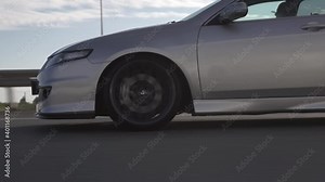 Side view of modern powerful car rides on summer highway. Footage. Perfect auto drives fast on country road.