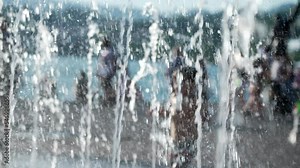 Happy kid having fun at water park jets in 120fps slow motion during heat summer day