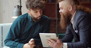 Two businessmen going over details of a business plan while sitting in a cafeteria, teal and orange, camera trucking movement