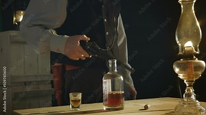 A cowboy from the American wild west era pulls out his Colt 1860 army conversion pistol as if ready to defend himself.