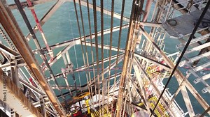 Top Drive System (TDS) running for jack up oil drilling rig, view from the top of the rig derrick