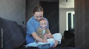 Woman with infant son makes inhalations using a nebulizer at home.