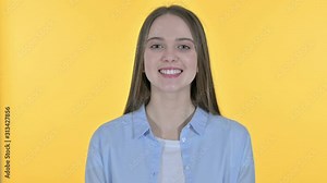 Casual Young Woman Saying Yes by Head Shake, Yellow Background
