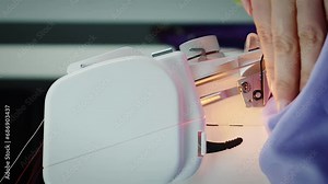 Details of working sewing machine. Sewing needle with thread. Vertical video