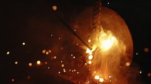 金属工事工場のエアーカーボンアーク切断。工場での金属部品溶接。たくさんの赤熱の火花が飛び交う。金属工場での危険な作業。重工業、金属加工。