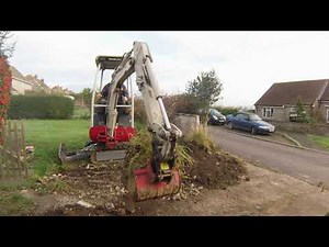 Digging out a driveway with a mini digger Takeuchi excavator