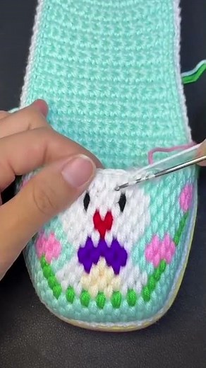 the process of knitting turquoise wool yarn using a special knitting tool