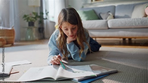 Unmotivated schoolgirl reading textbook lying floor closeup. Tired preteen girl