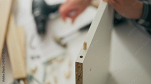 Furniture, Woman in hand by herself Carefully Repairs home furniture using a tool In a private house, Close-up Young professional Assembles new furniture in a new house Is at workplace self-assembly